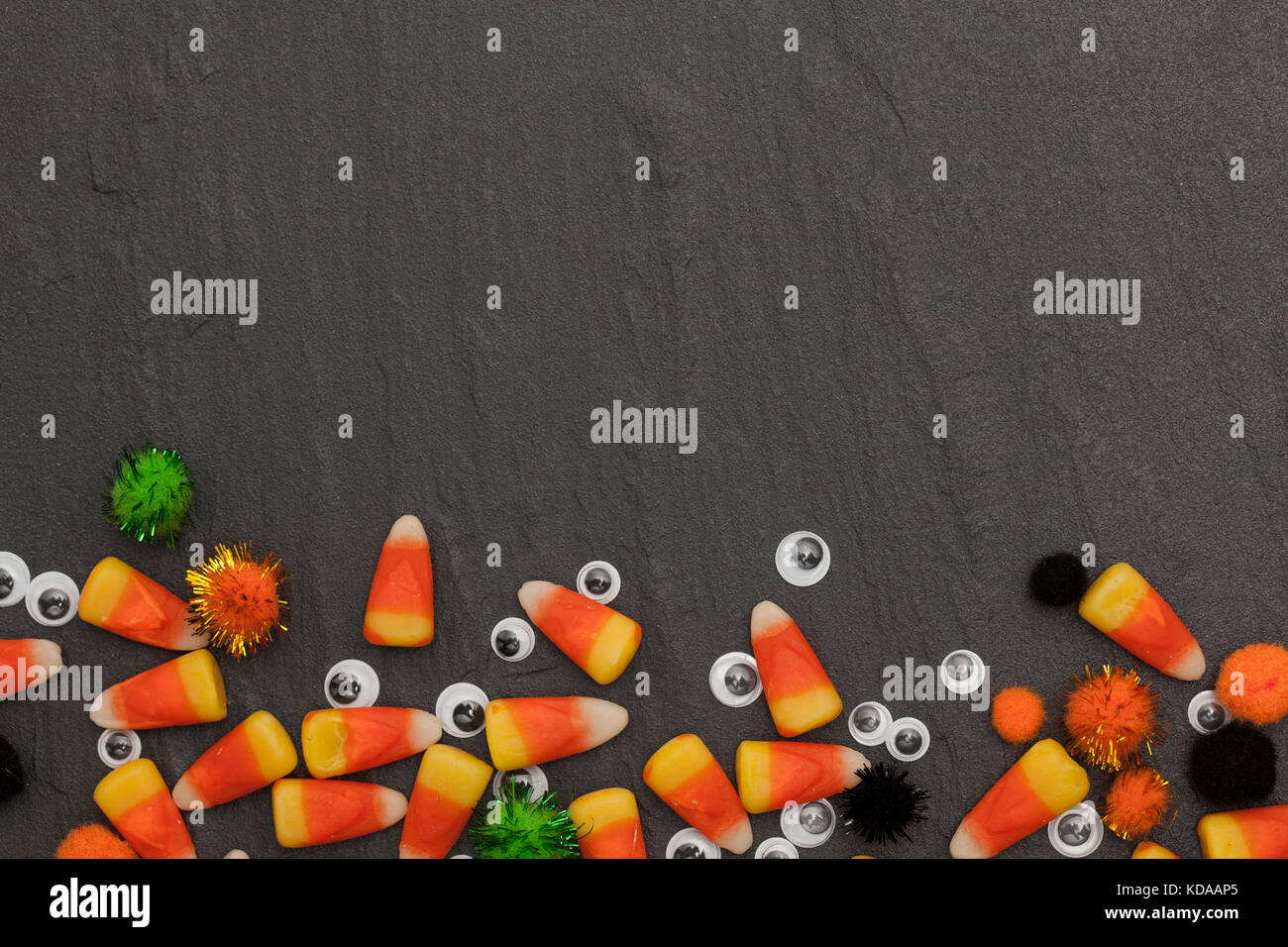 Halloween candy corn sweets and googly eyes background Stock Photo - Alamy