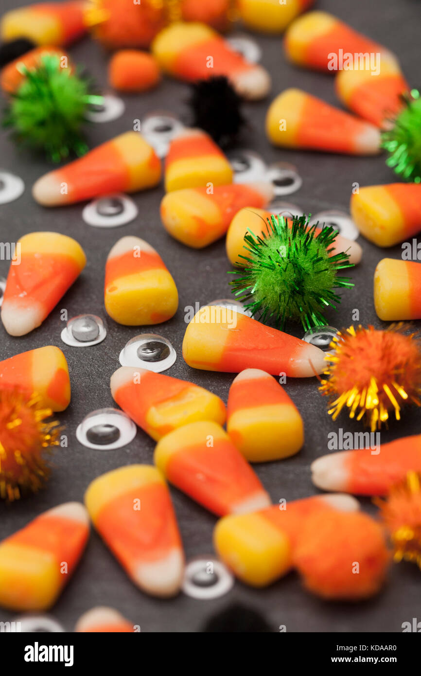 Halloween candy corn sweets and googly eyes background Stock Photo - Alamy
