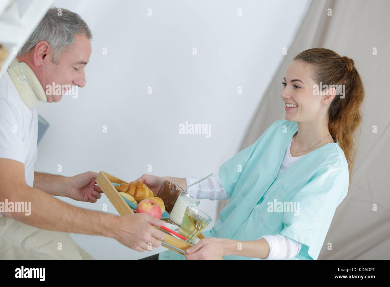 happy nurse giving food to senior man at home Stock Photo - Alamy