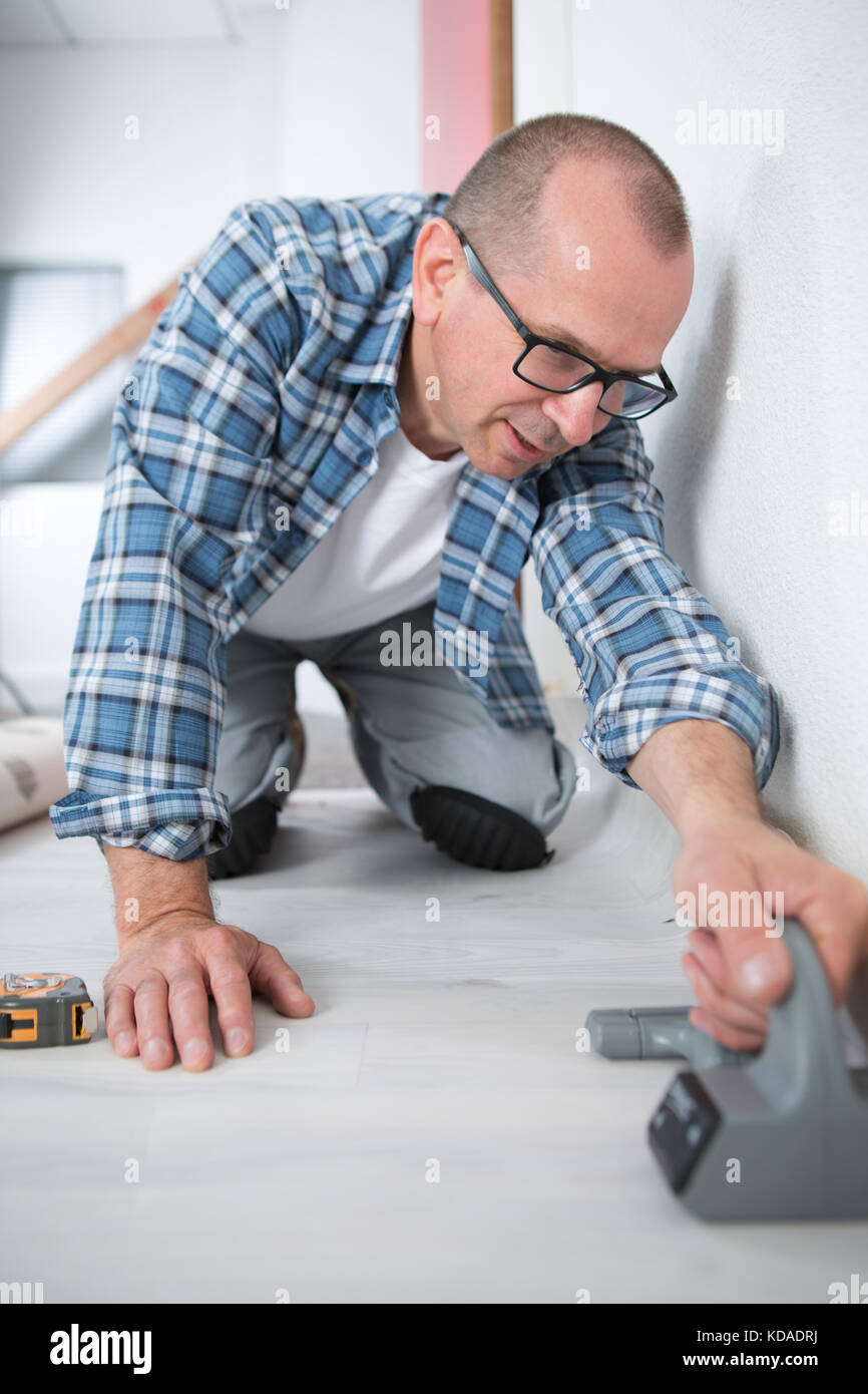 male craftsman fitting carpet on floor Stock Photo - Alamy