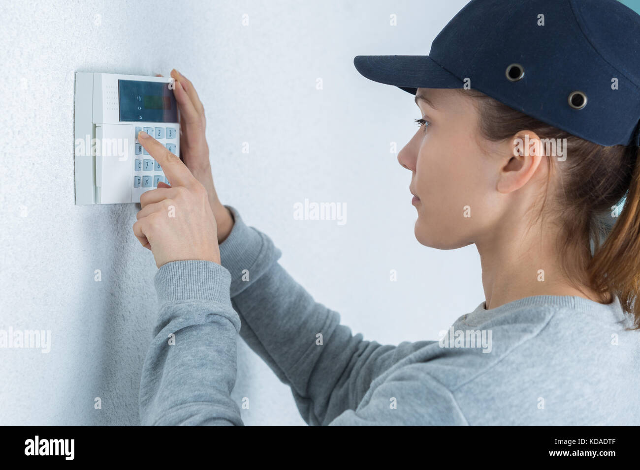 female worker entering code on electronic keypad on wall Stock Photo ...