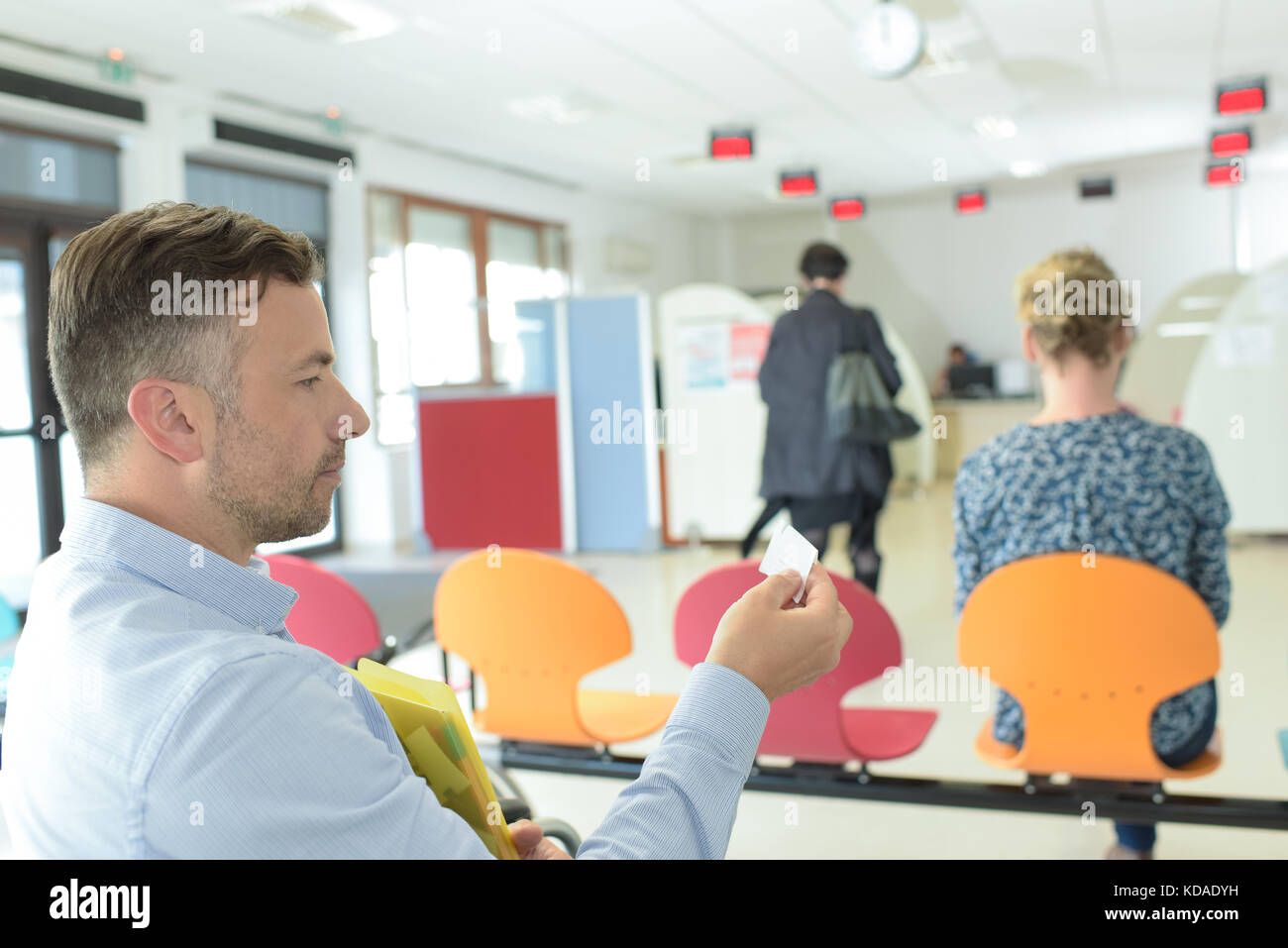 man waiting while looking at his ticket Stock Photo - Alamy