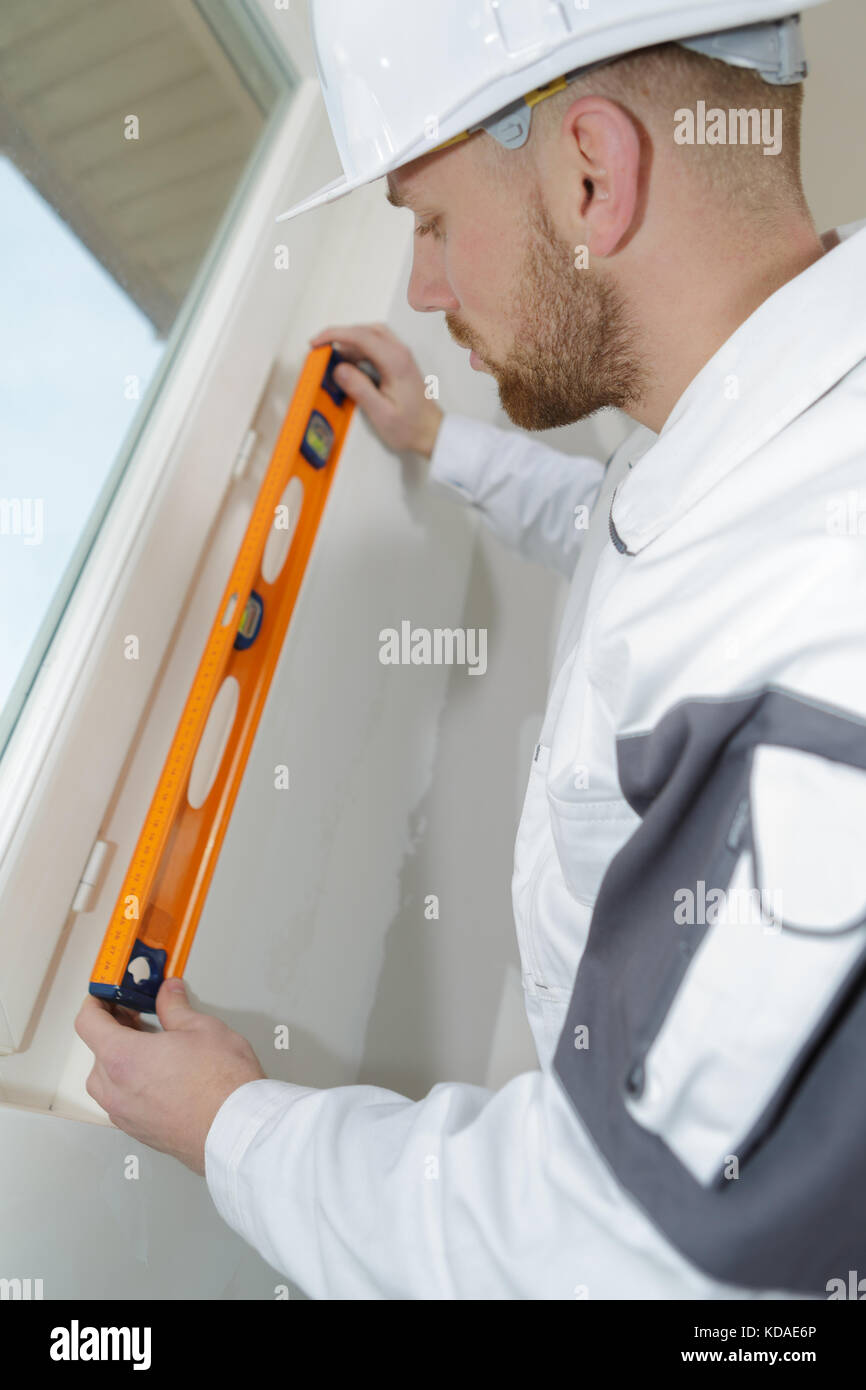 builder posing with spirit level at construction site Stock Photo - Alamy