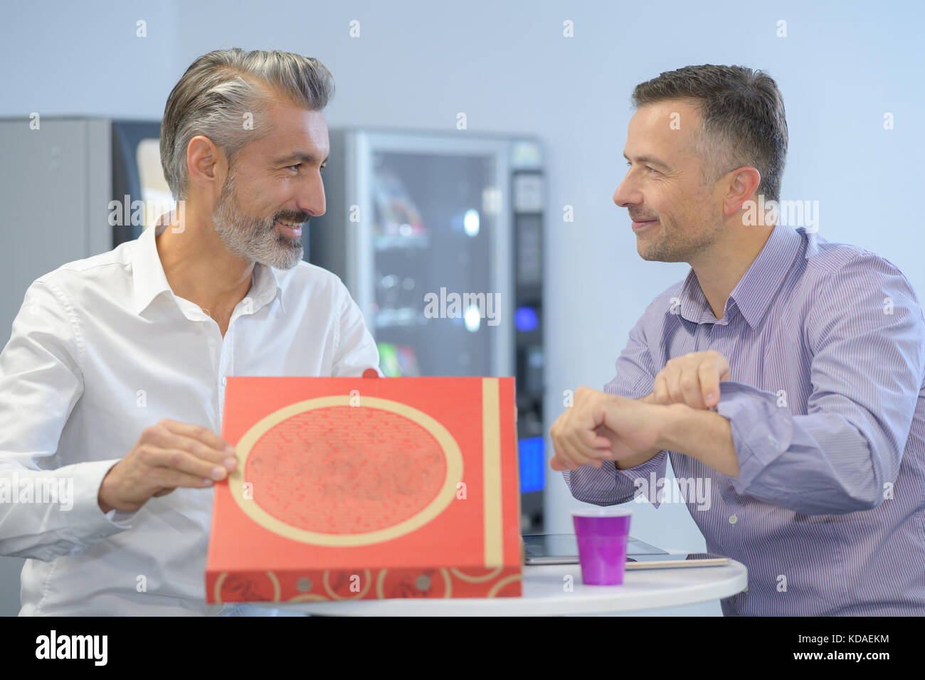 office workers using computer and eating pizza Stock Photo - Alamy