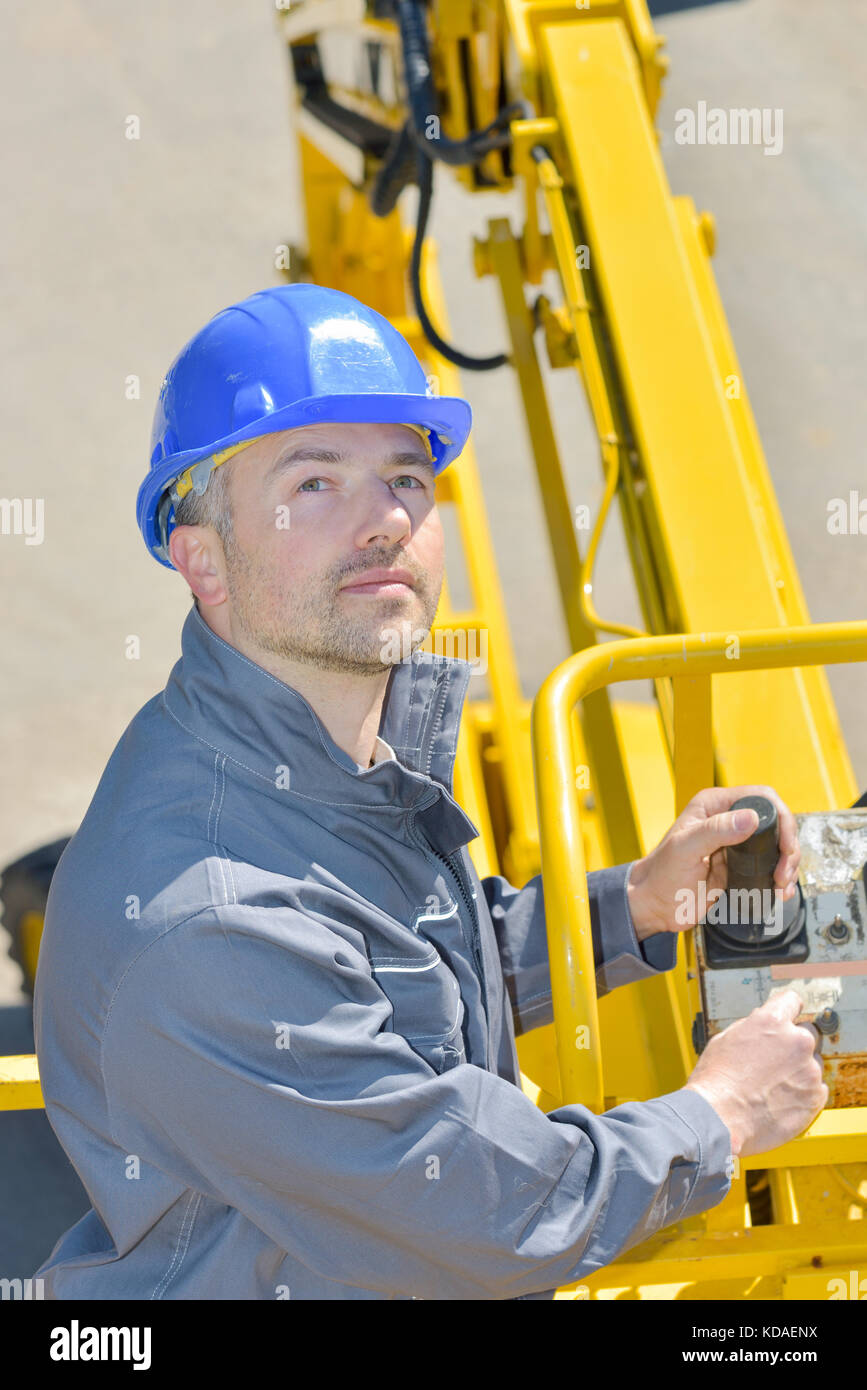 worker using a yellow crane in a site Stock Photo - Alamy