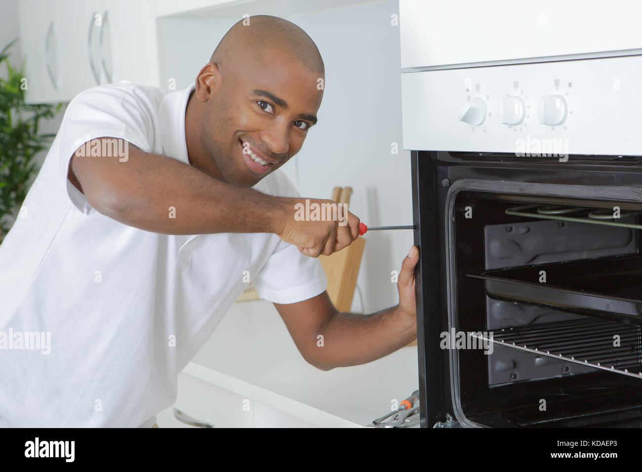 Portrait of man fitting oven Stock Photo - Alamy