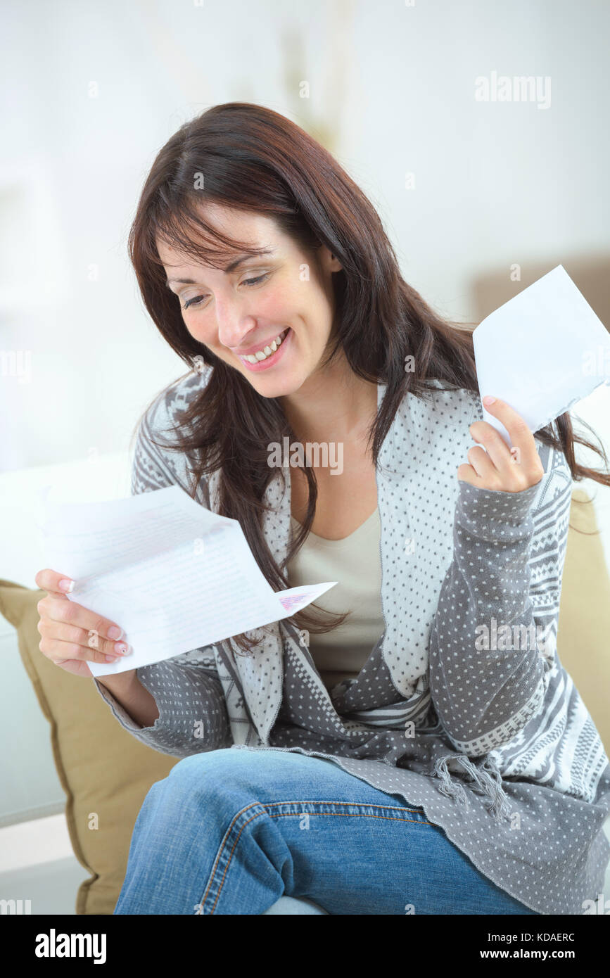 cheerful long-haired woman reading documents Stock Photo - Alamy