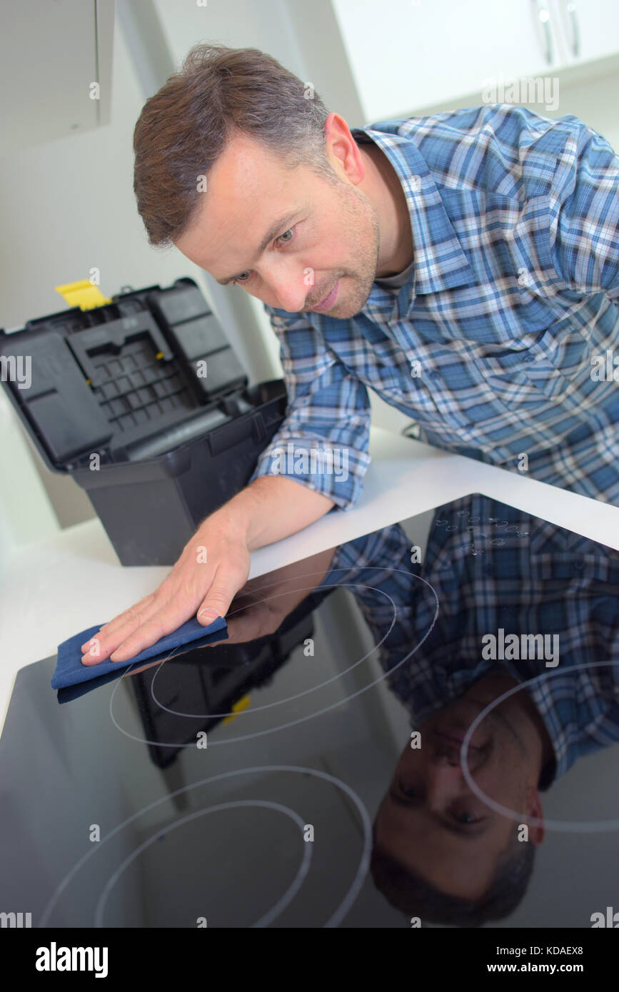 Man working on induction hob Stock Photo - Alamy