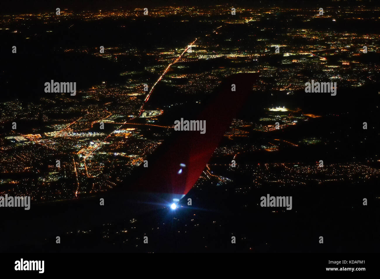 View of night city under the wing of airplane flying high Stock Photo ...