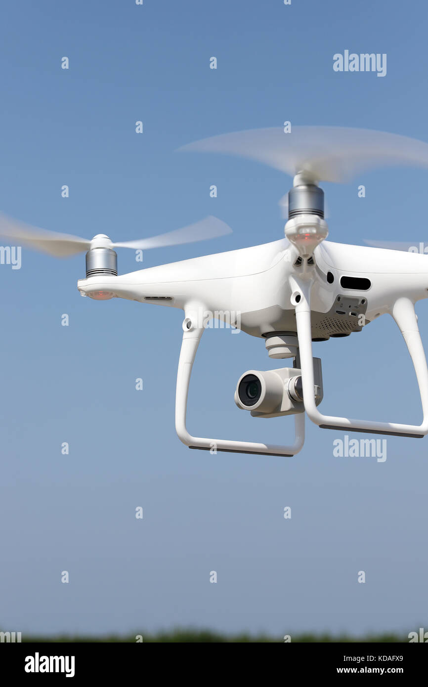 White drone flying in air and clear blue sky Stock Photo - Alamy