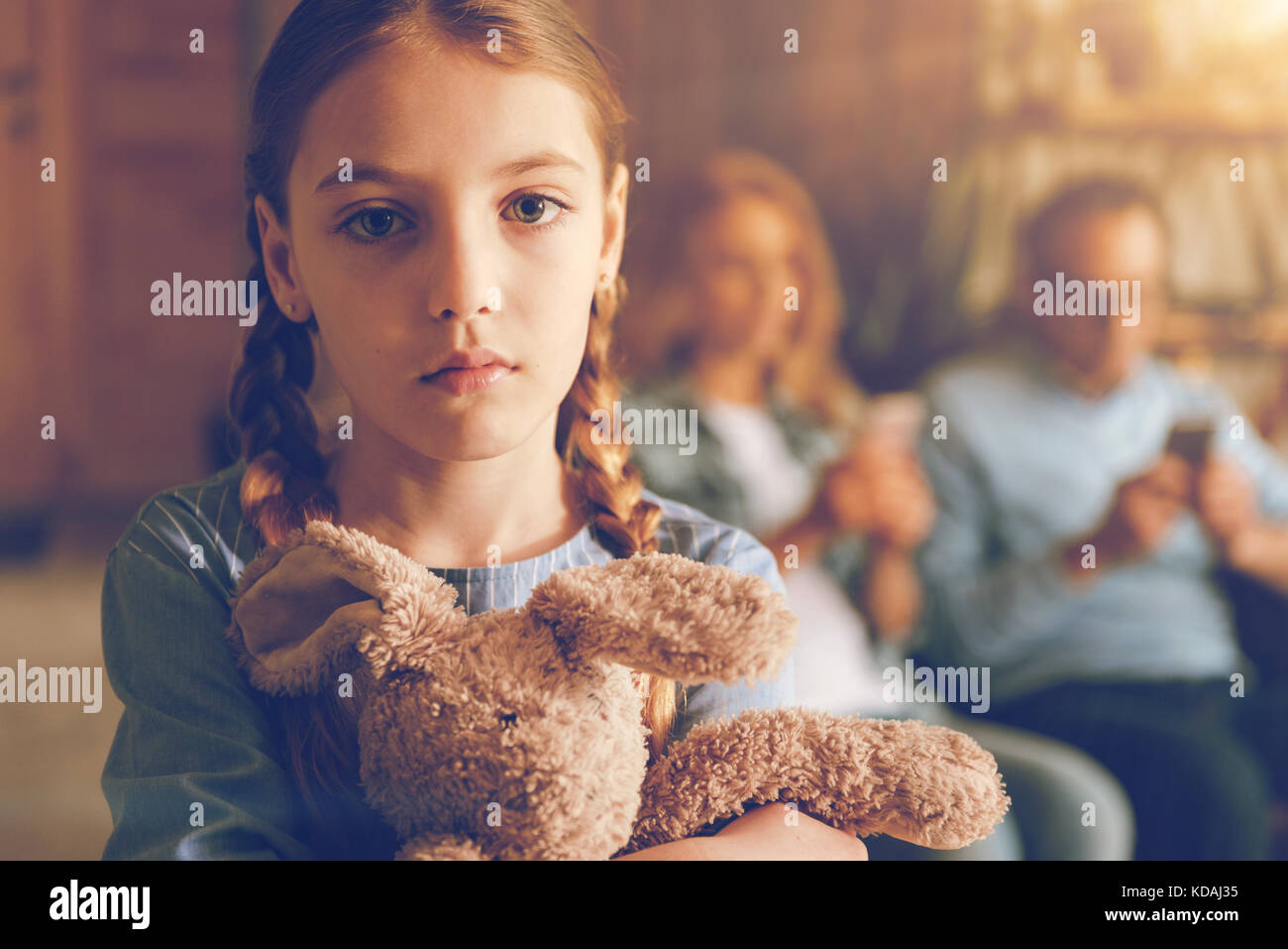 Sad girl waiting for parents to pay attention to her Stock Photo - Alamy