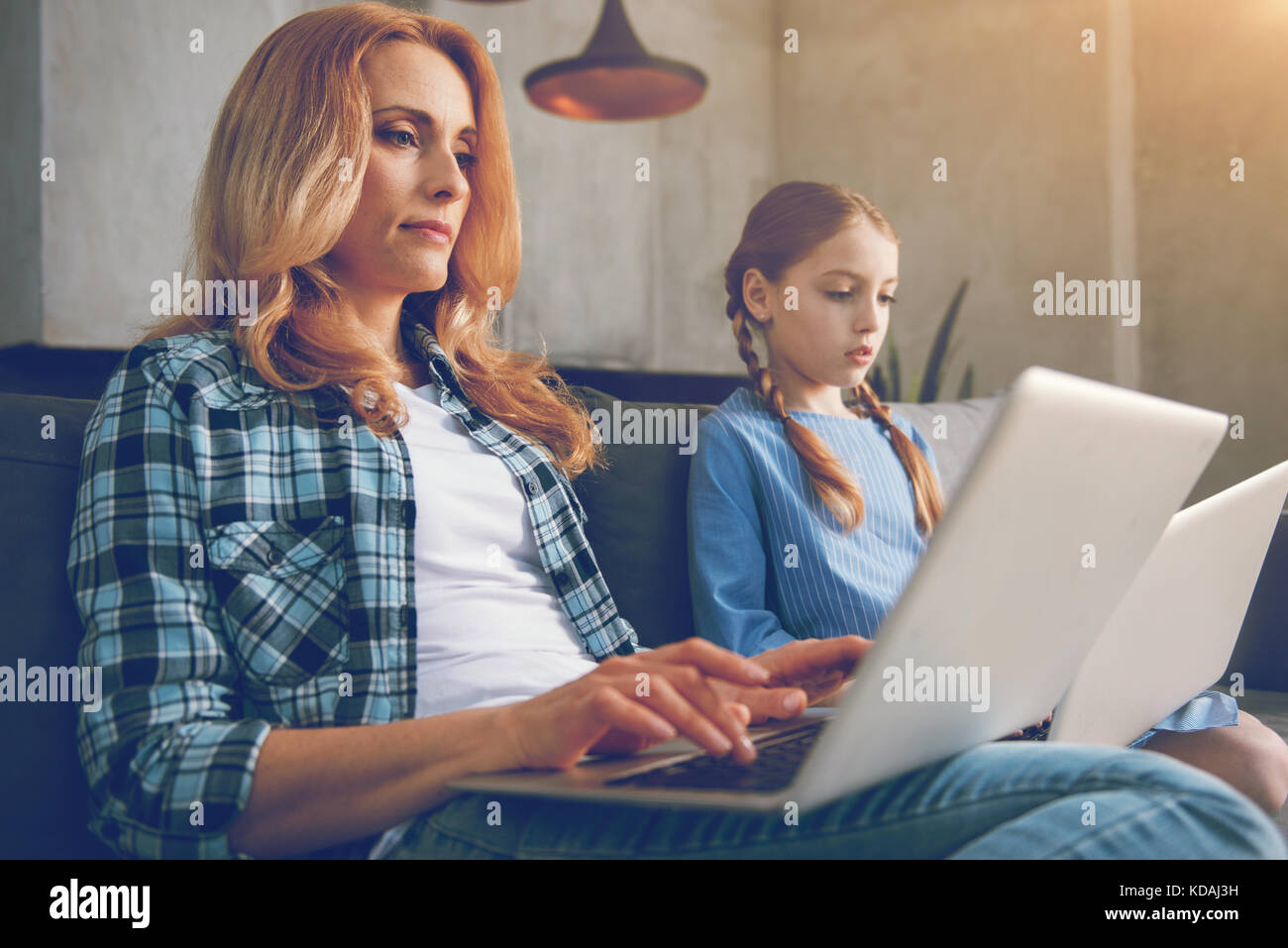 Focused parent and child using laptops at home together Stock Photo - Alamy