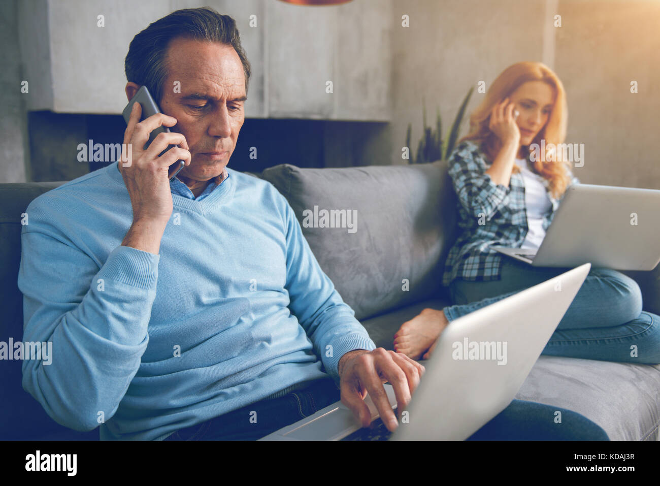 Mature couple busy working from home Stock Photo - Alamy