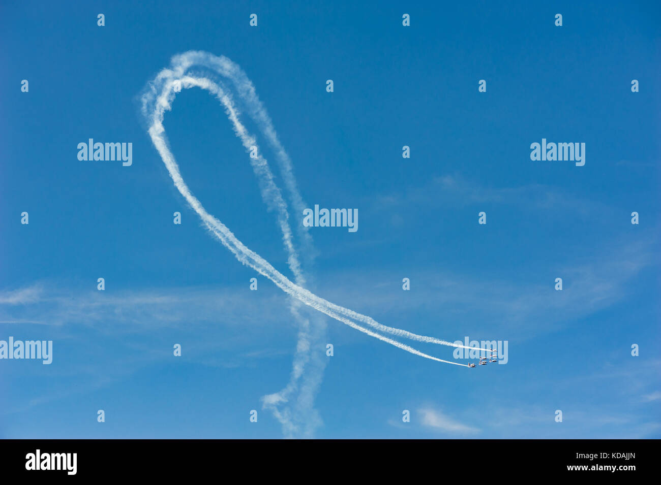 Planes in formation doing a loop with white smoke trail in blue Stock ...
