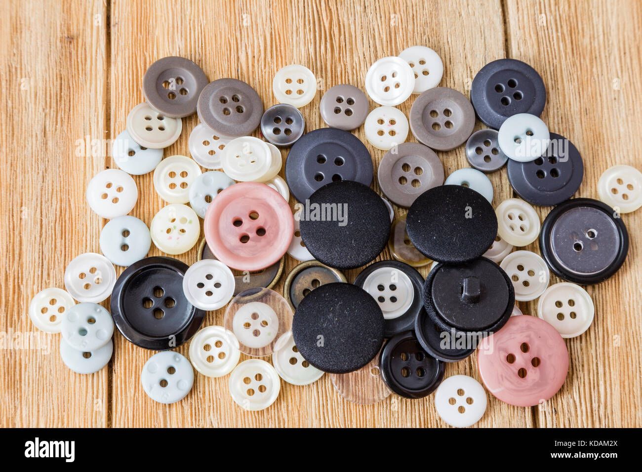 Various sewing buttons and safety pins on a wooden table Stock Photo ...