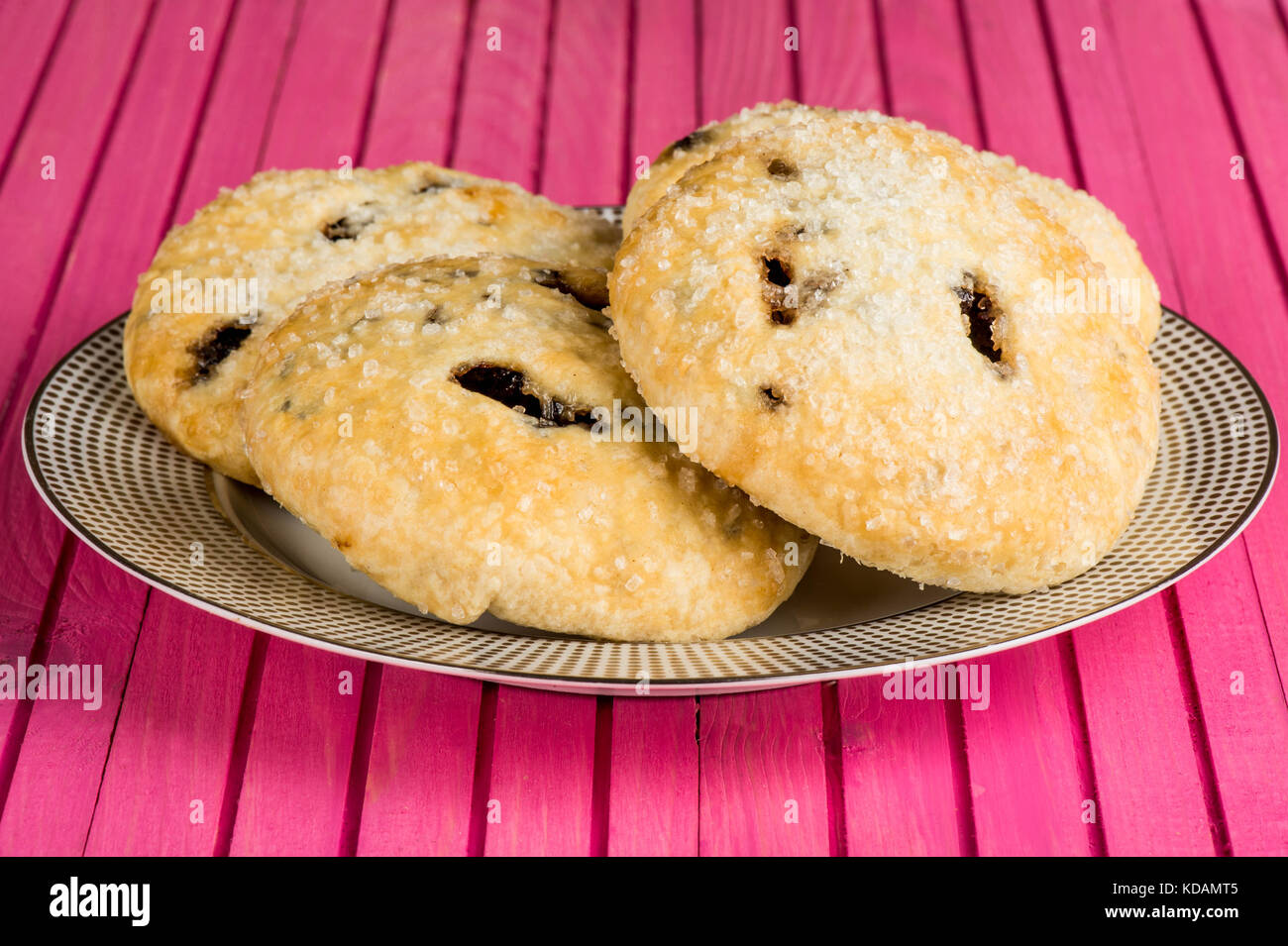 Puff Pastry Butter Eccles Cakes With A Currant Filling Against a Pink ...