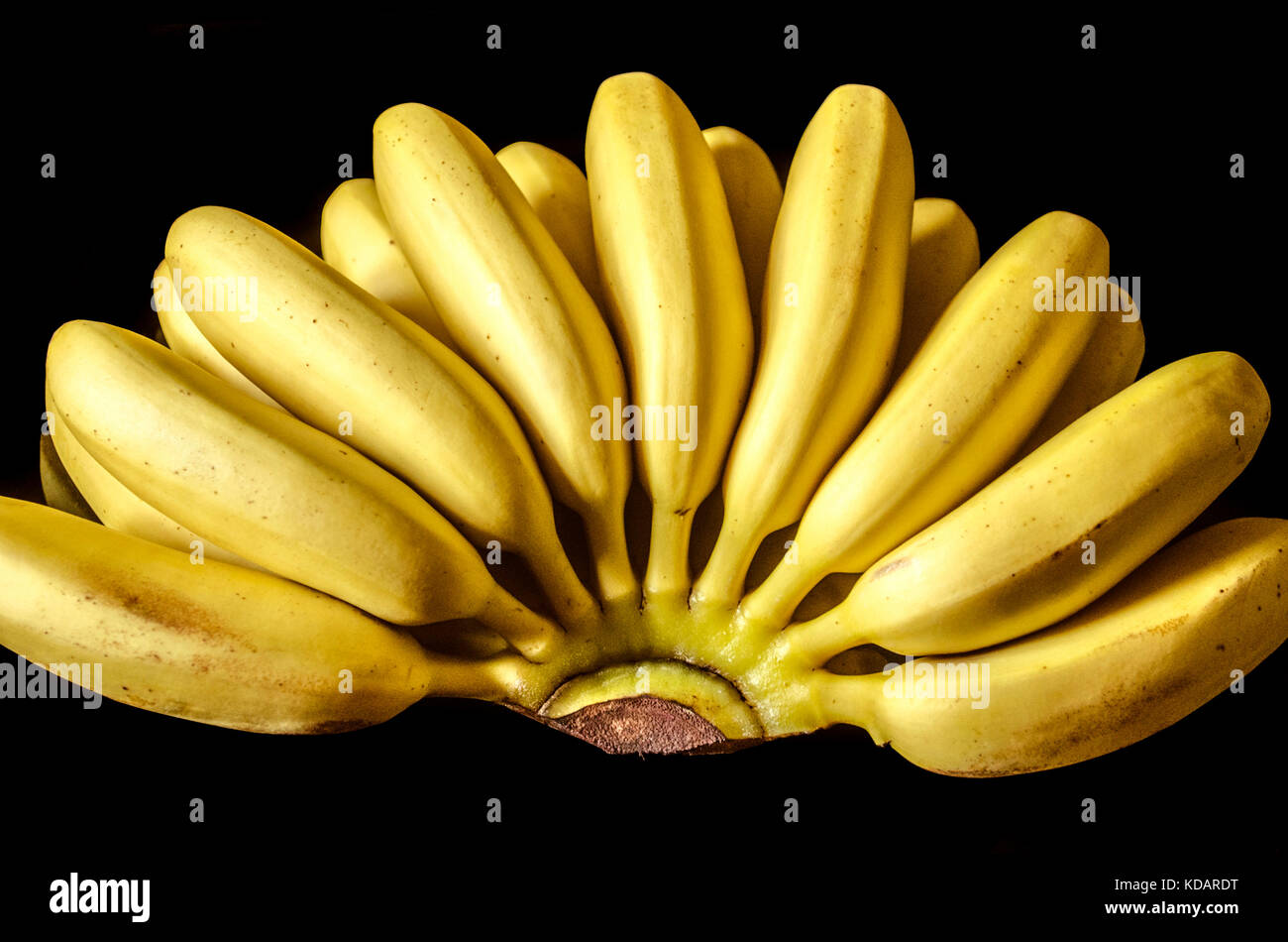 Bunches of ripe small bananas on a black background Stock Photo - Alamy