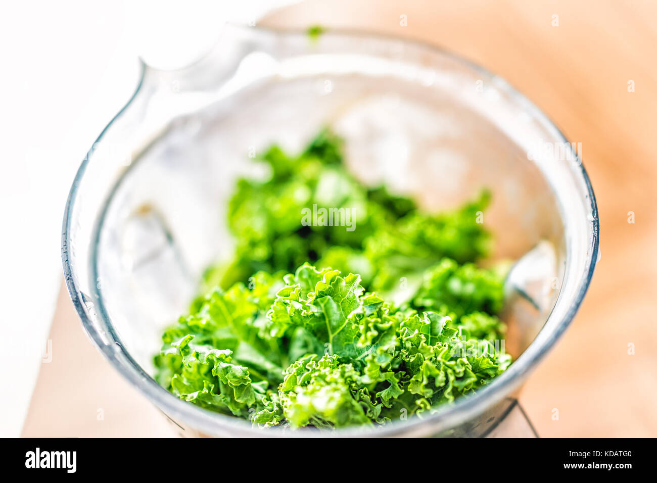 Macro closeup of fresh green kale in plastic blender container for ...
