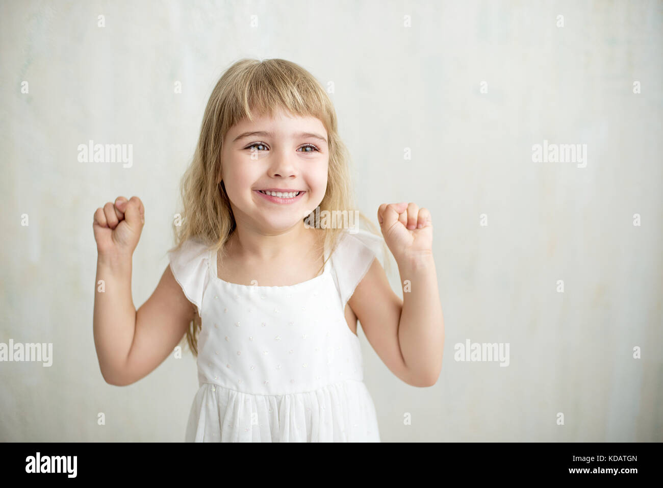smiling child girl with hands up isolated on background Stock Photo - Alamy