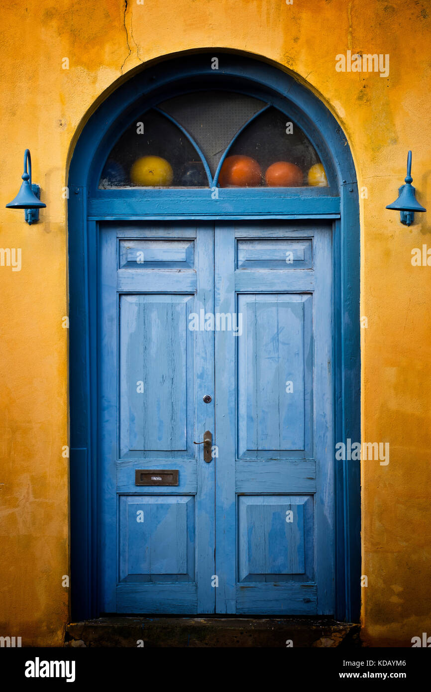 Yellow walled building with arched blue windows and door Stock Photo ...