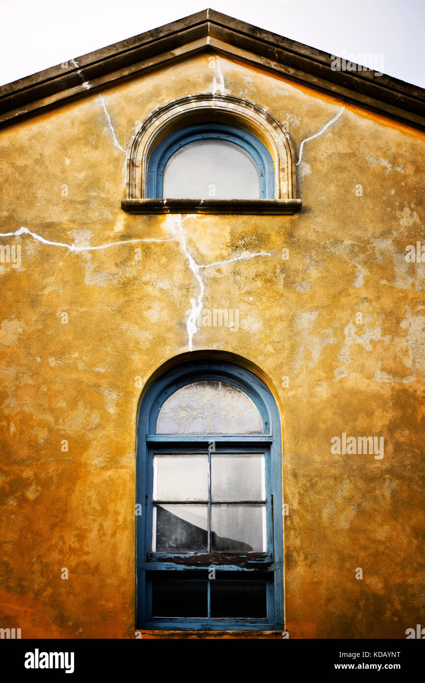 Yellow walled building with arched blue windows and door Stock Photo ...