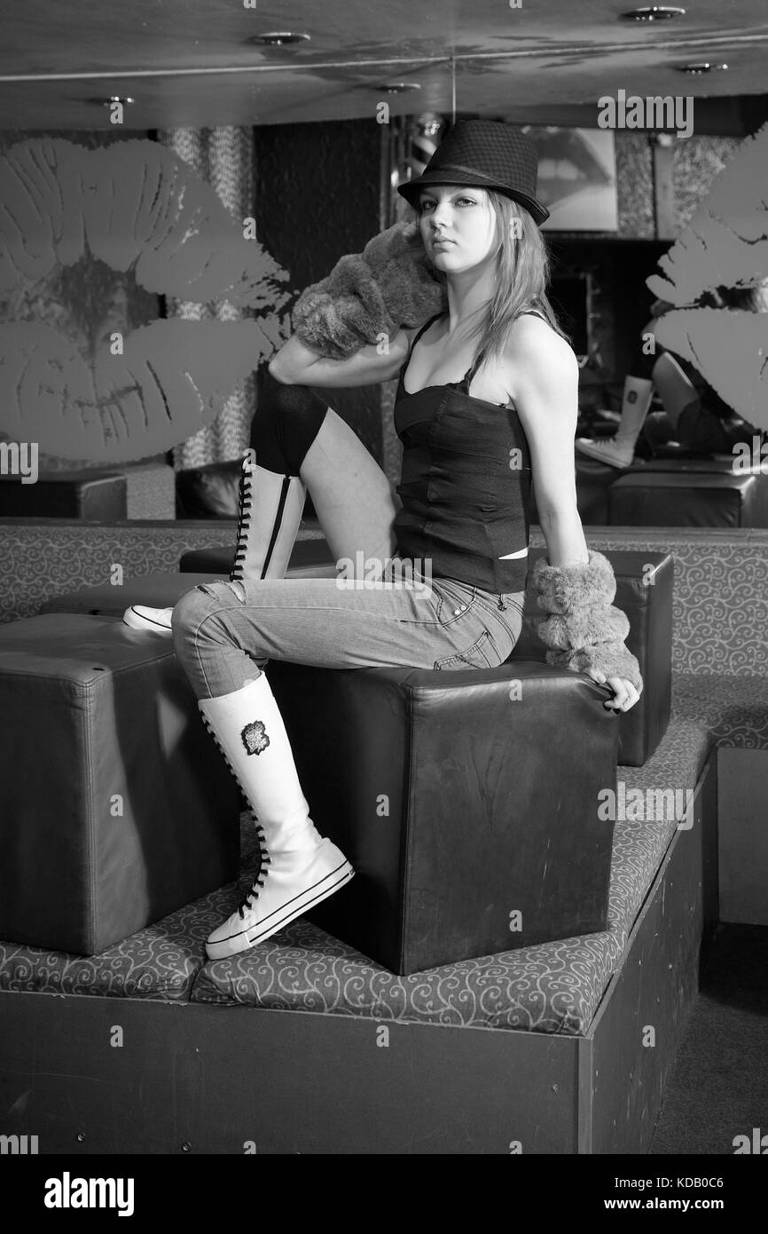 Pretty girl lounging on cubes wearing white boots and a hat Stock Photo ...