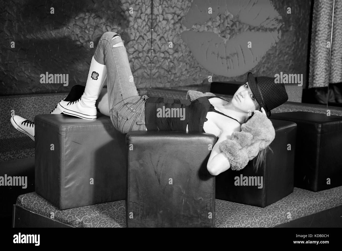 Pretty girl lounging on cubes wearing white boots and a hat Stock Photo ...