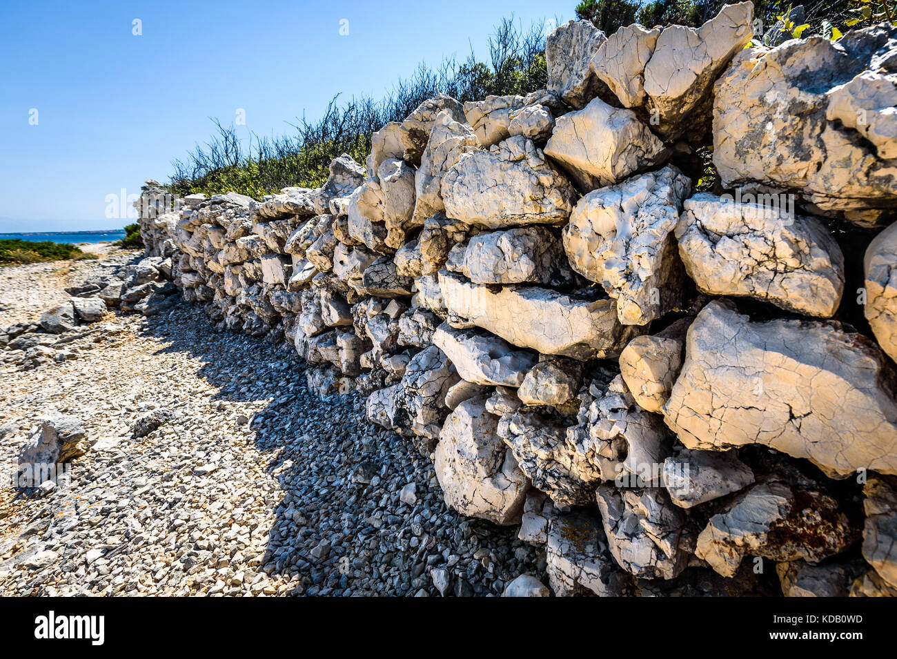 Stone rock fence or gabion on the beach in Croatia. Old built rock wall ...