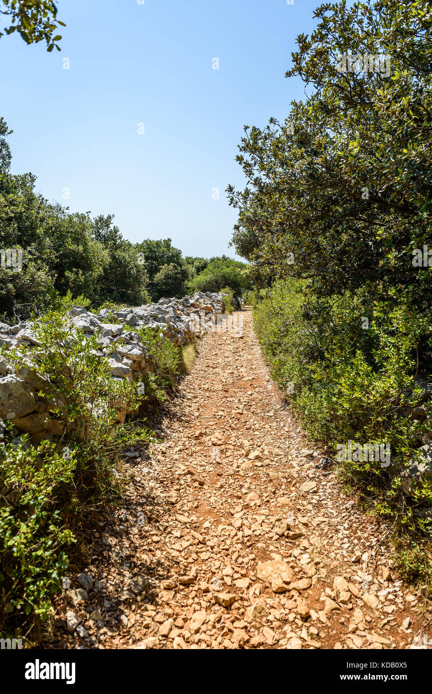 Stone rock fence or gabion and road or footpath. Old built rock wall ...
