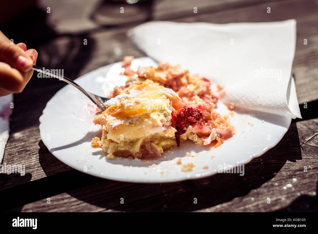 Children eating cheese and cherry strudel with sugar on top. Child's ...