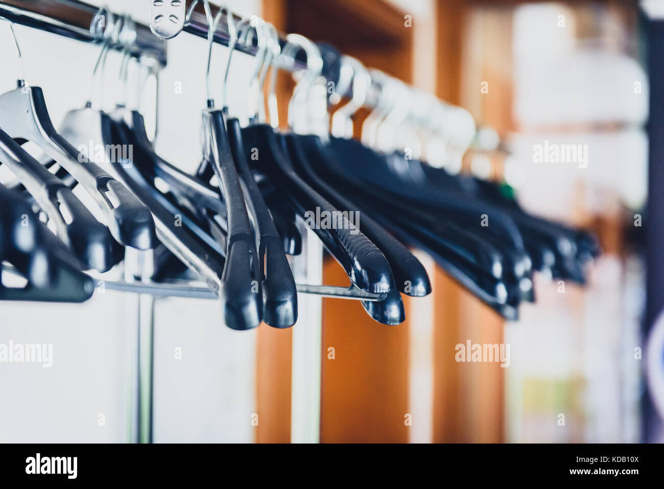 Empty wardrobe stand with black hangers at business event venue. Empty ...