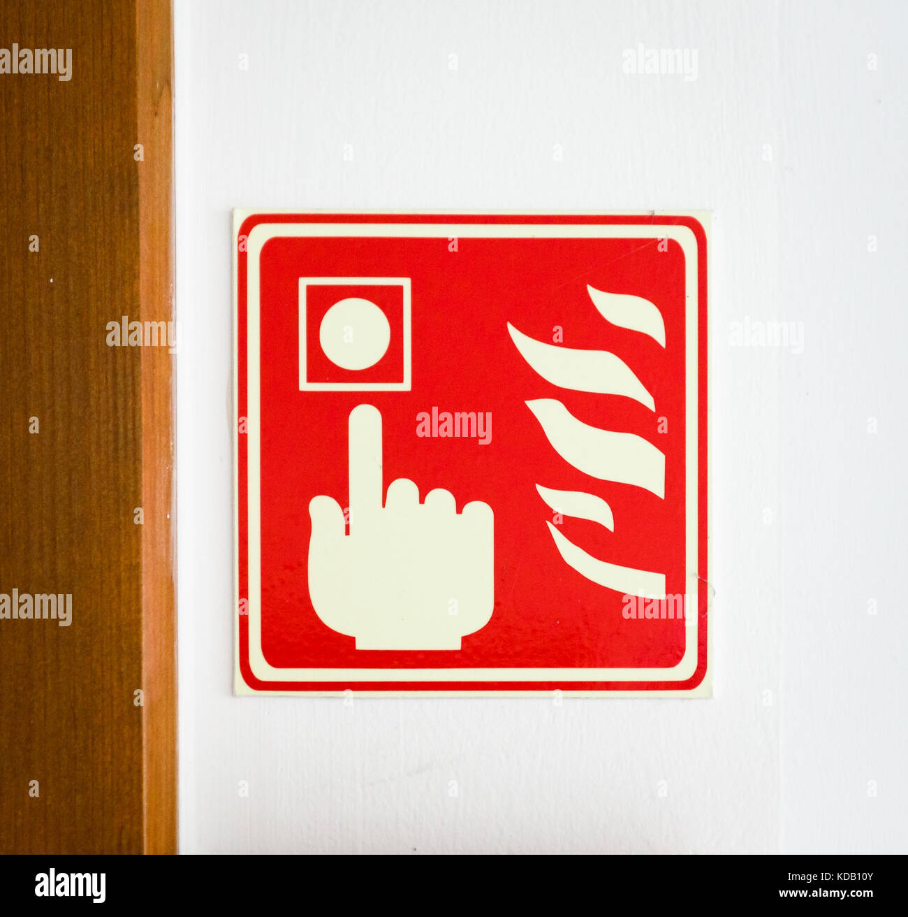 Emergency fire alarm safety call point sign on a wall. A photograph of ...