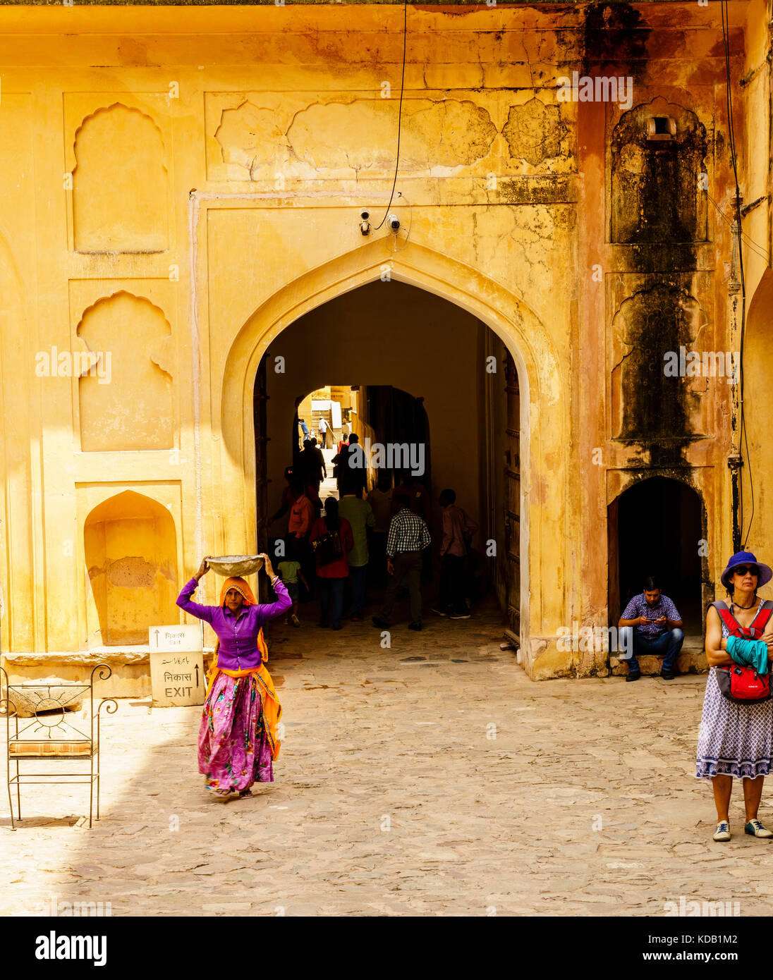 An India woman carrying a pan on her head at a palace building in ...