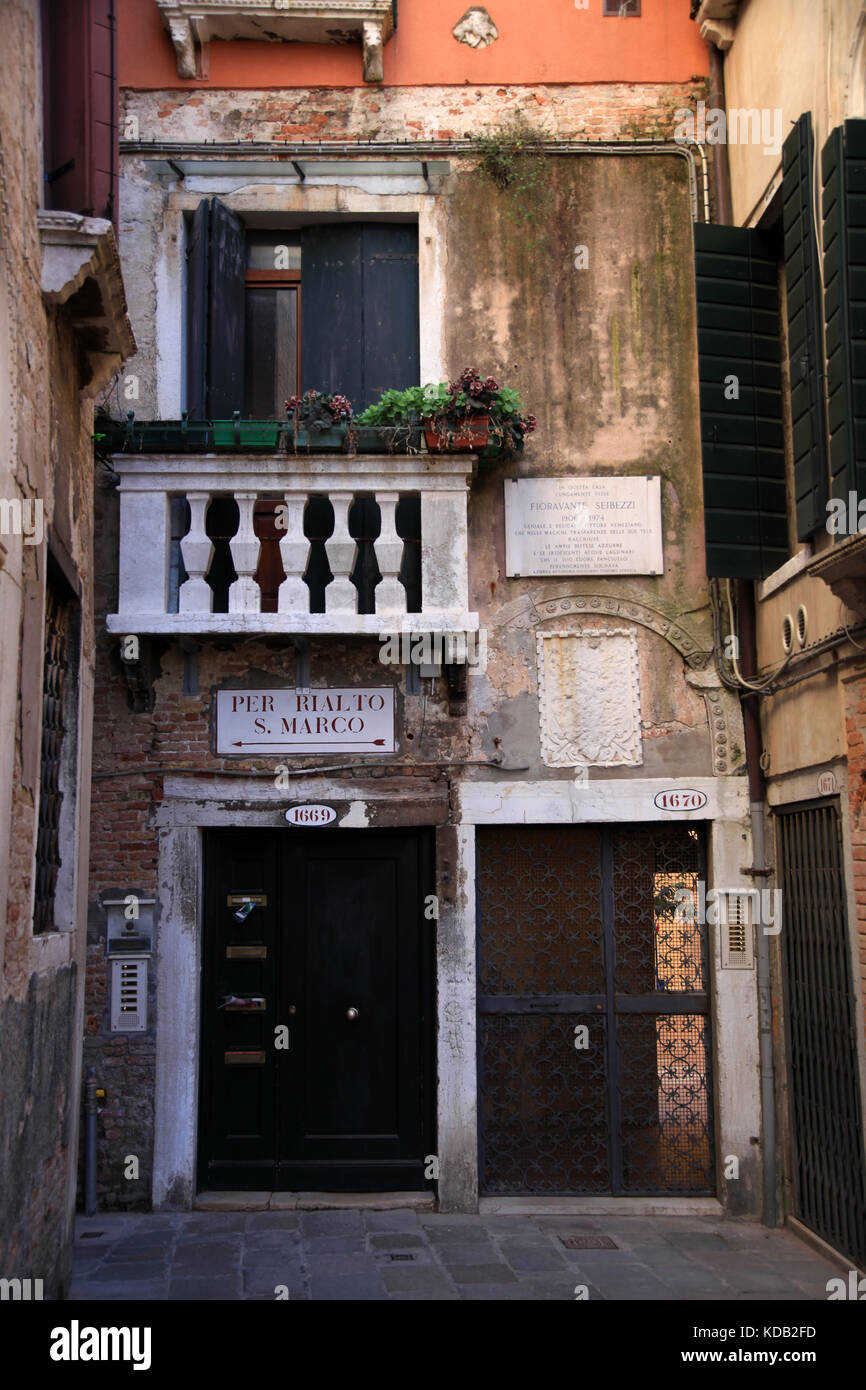 Narrow path between houses and buildings in Venice. With directions to ...