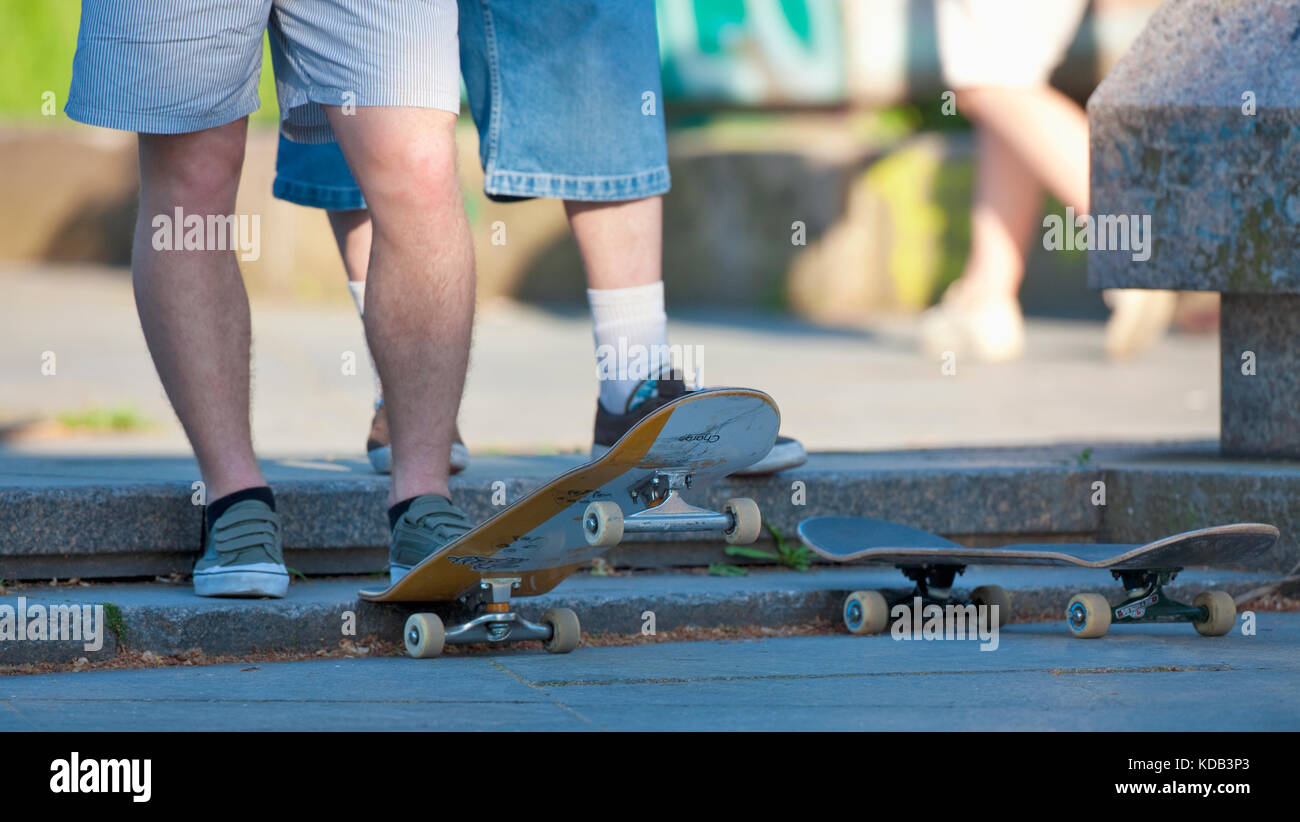Skateboarding - detail of skateboard and legs with trainers Stock Photo ...