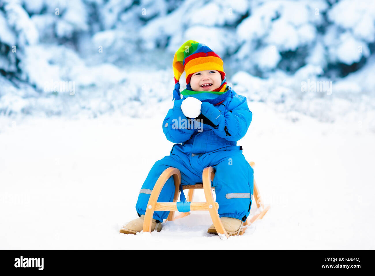 Little boy enjoying a sleigh ride. Child sledding. Toddler kid riding a ...