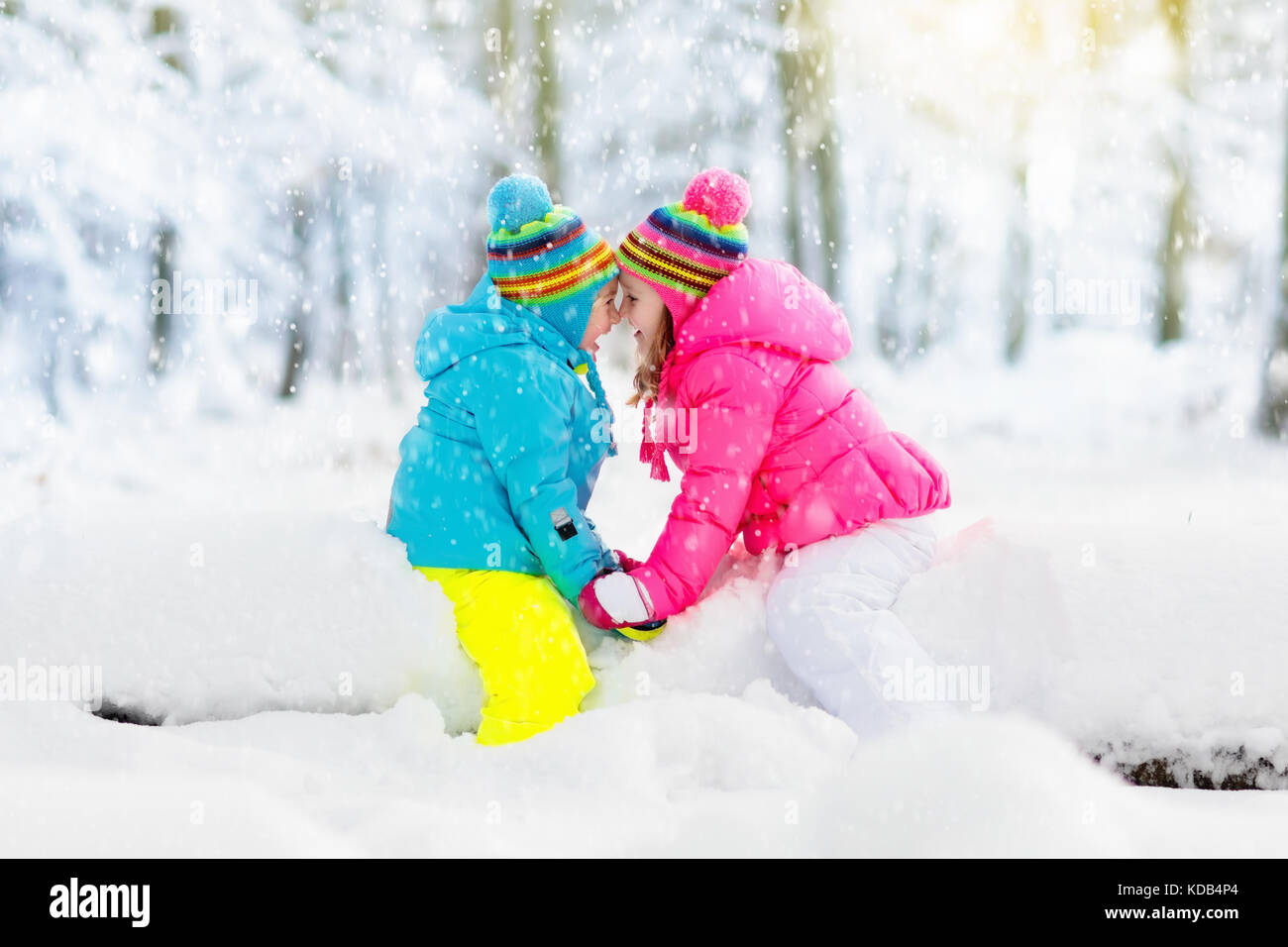 Kids playing in snow. Children play outdoors on snowy winter day. Boy ...