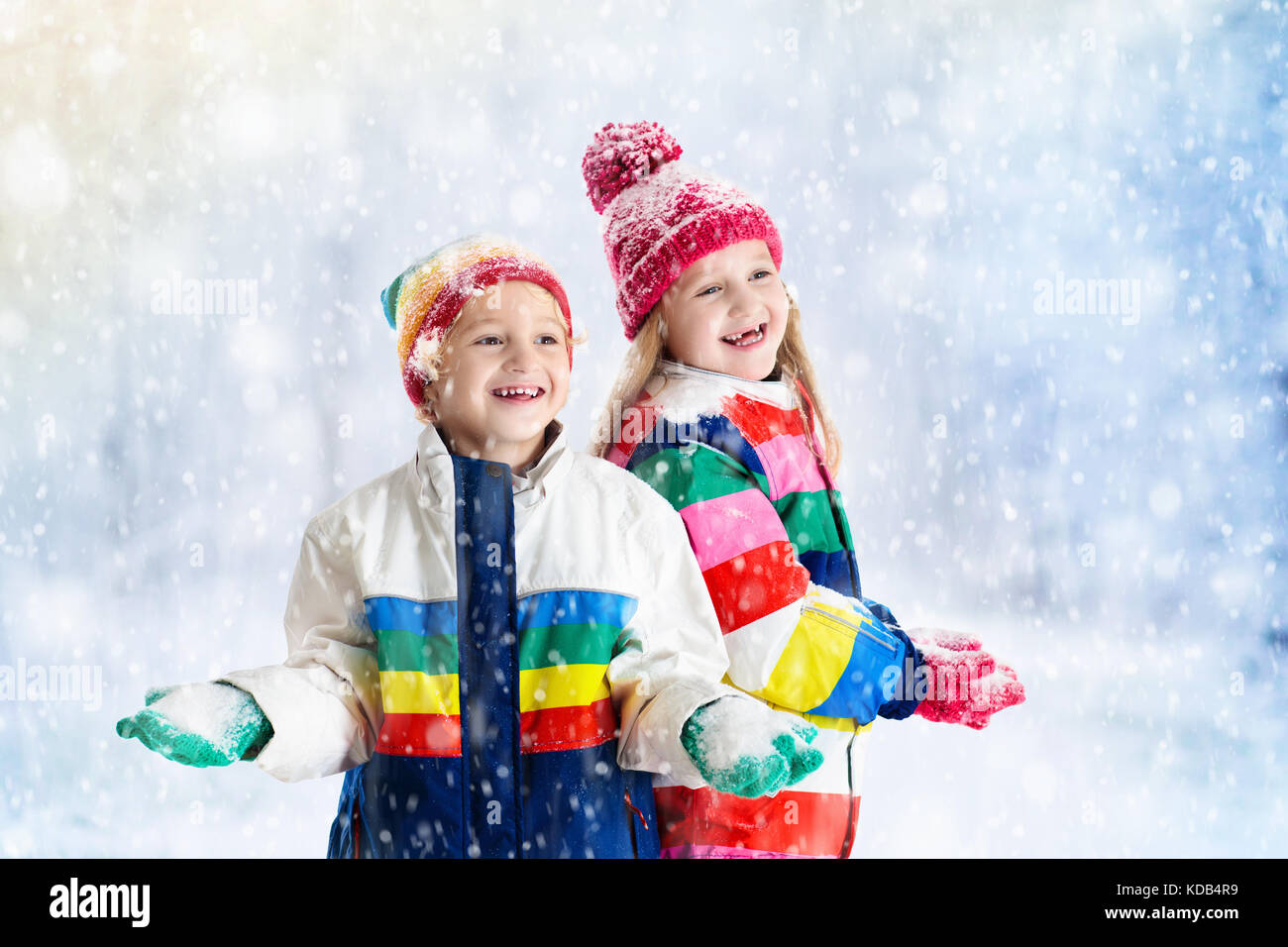 Kids playing in snow. Children play outdoors on snowy winter day. Boy ...