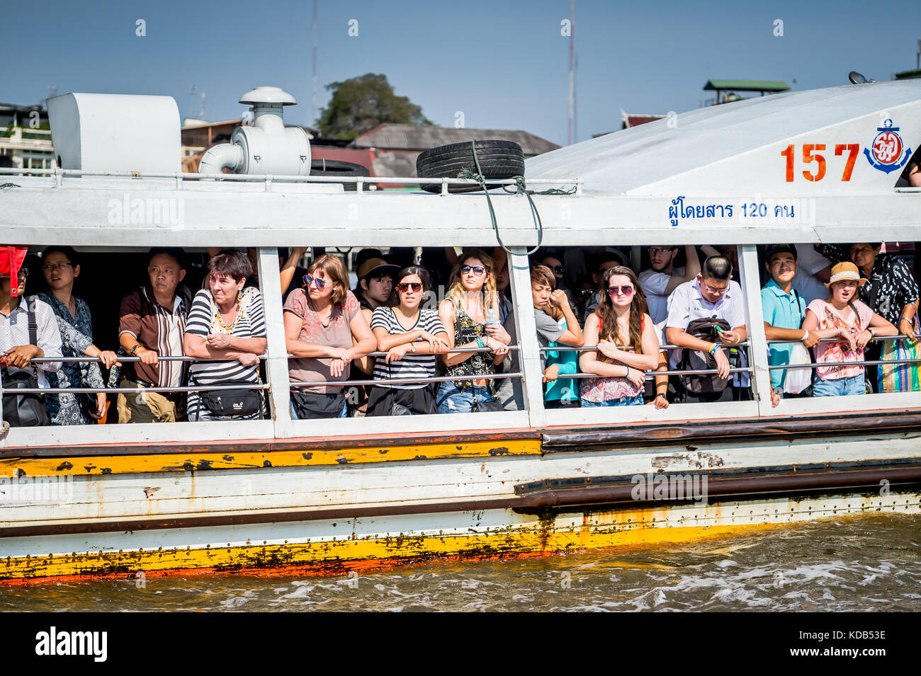 Tourists aboard a typical ferry running the length of the Chao Phraya ...