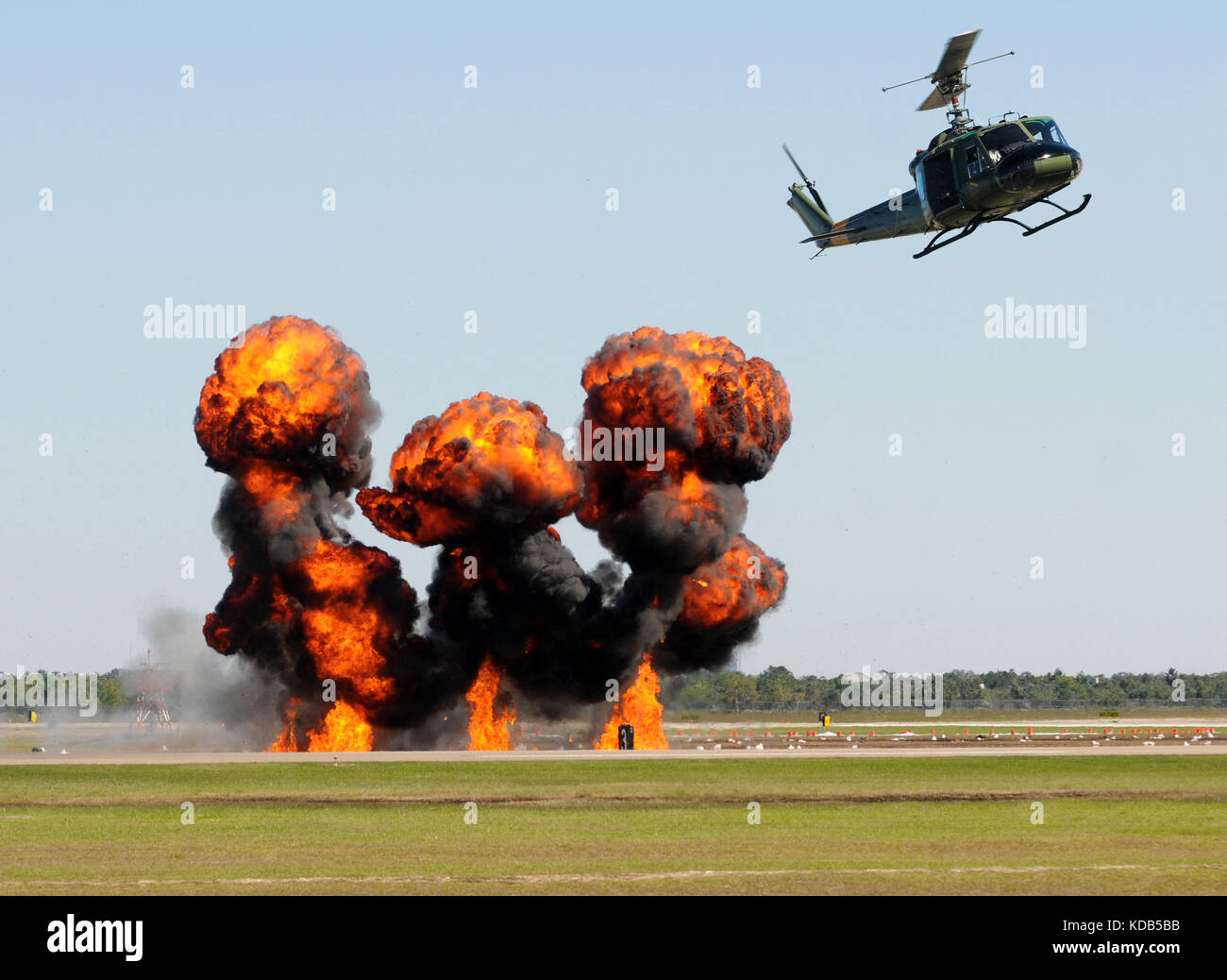 Helicopter flying over fiery ground explosion Stock Photo - Alamy