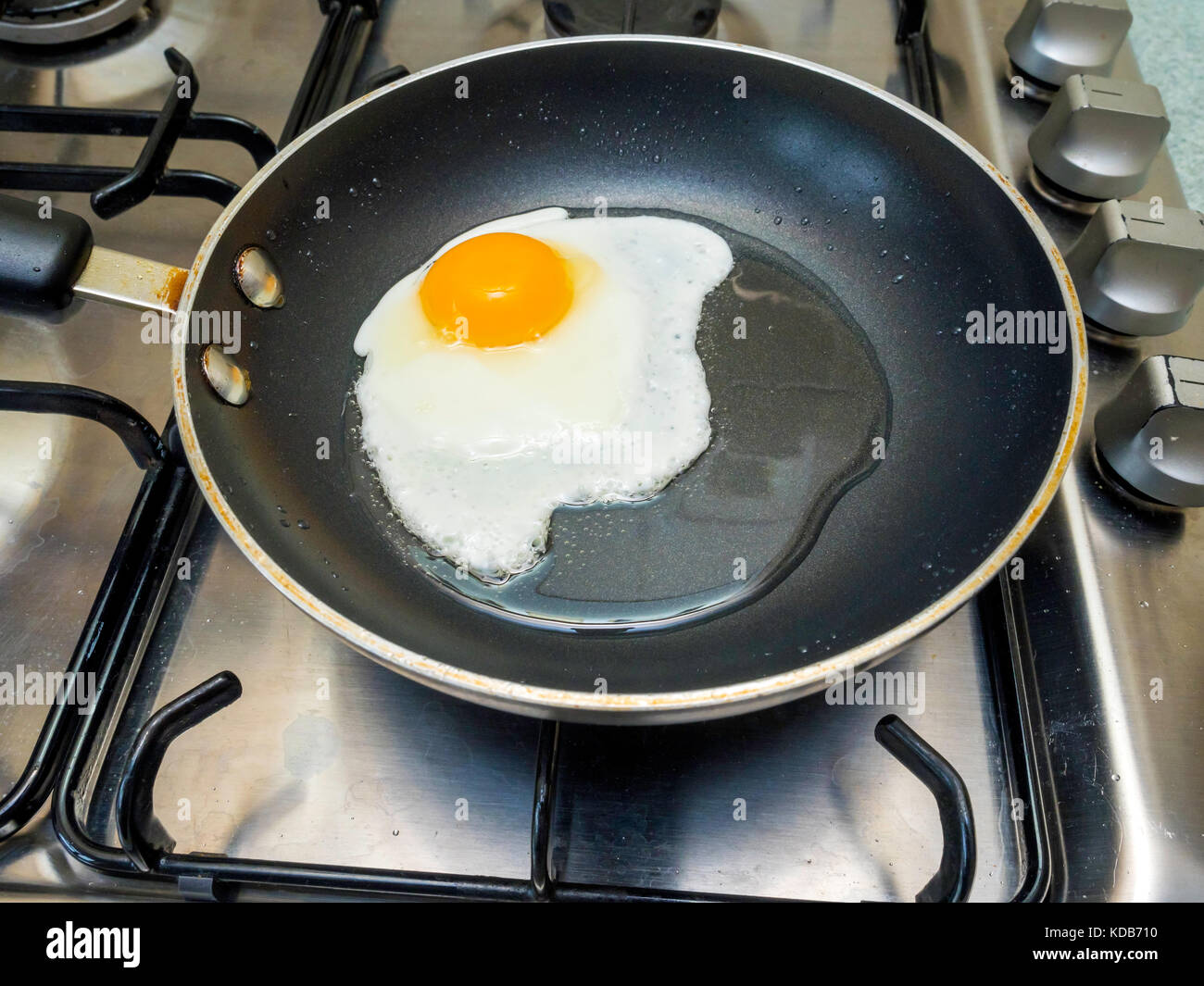 An egg being fried in sunflower oil in a small Teflon coated non stick ...
