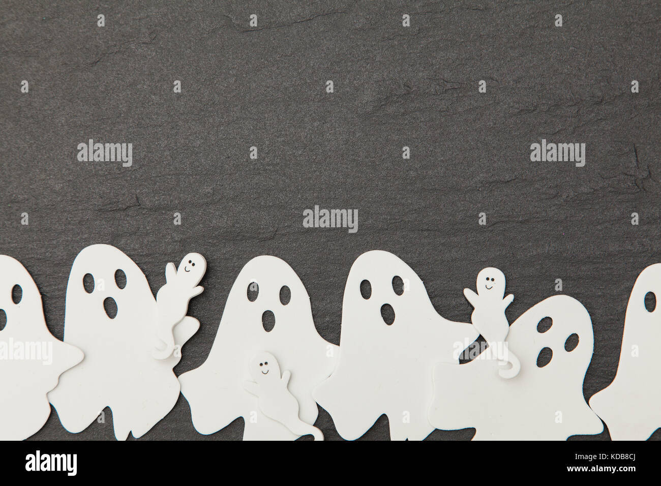 Halloween ghost shapes on a slate background Stock Photo - Alamy