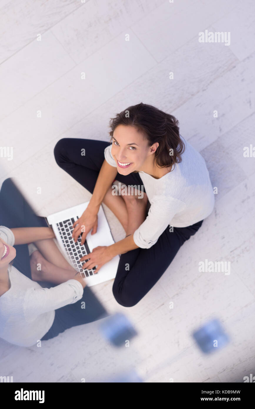 top view of a beautiful young women using laptop computer on the floor ...