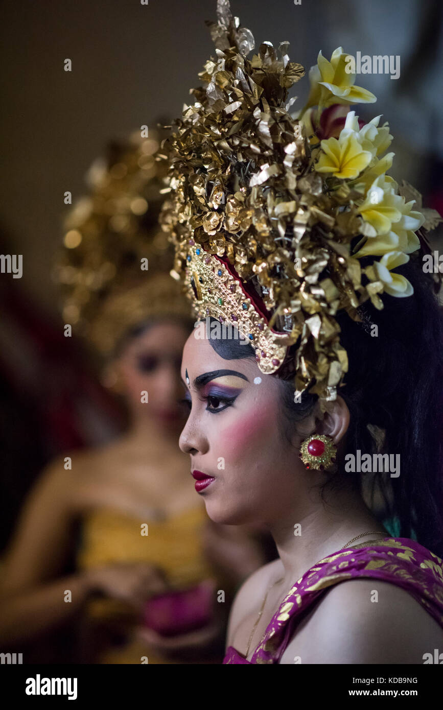 A female Balinese legong dancer getting ready before the show in Ubud ...