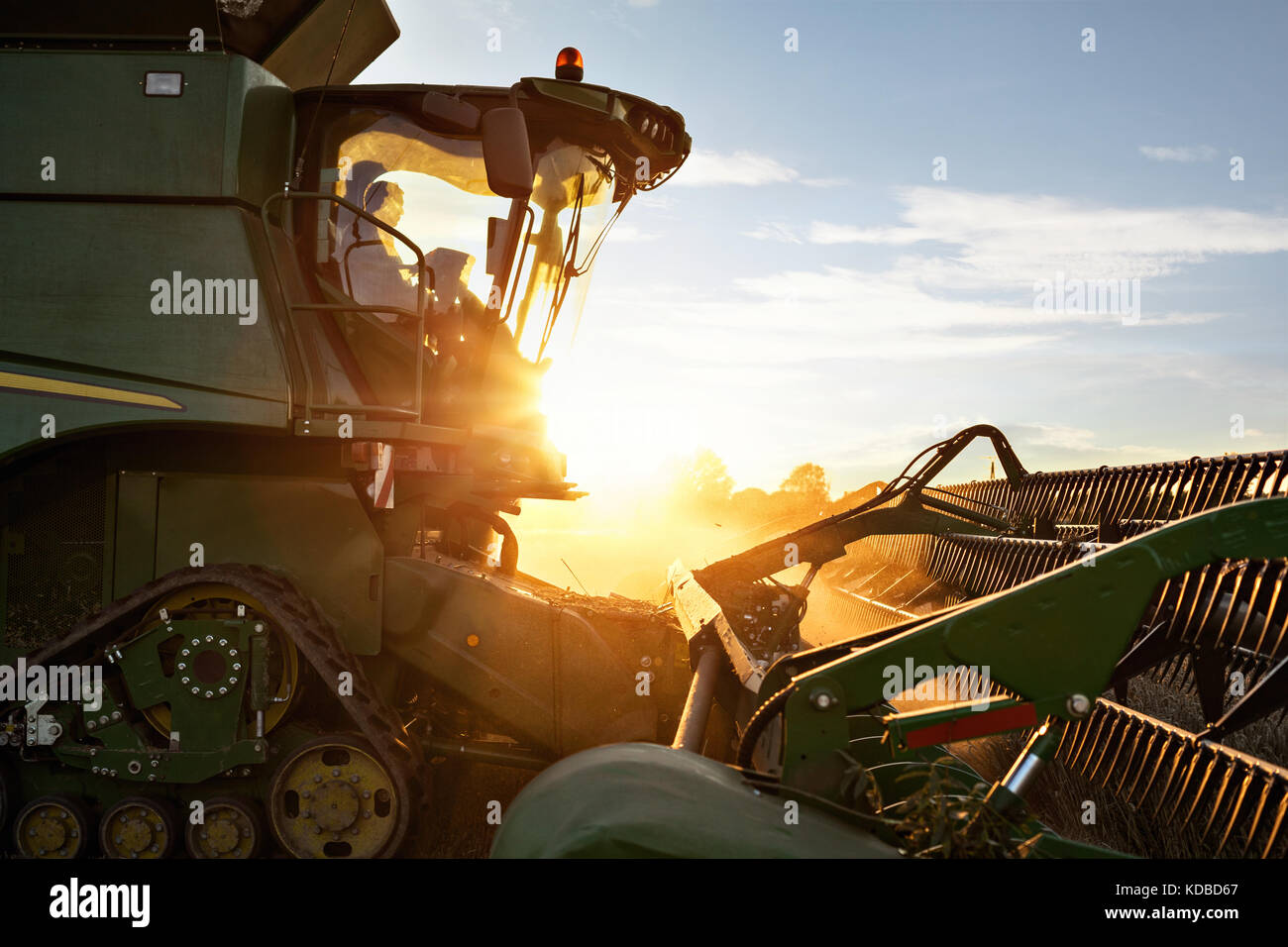 Front of a combine harvester with setting sun Stock Photo - Alamy