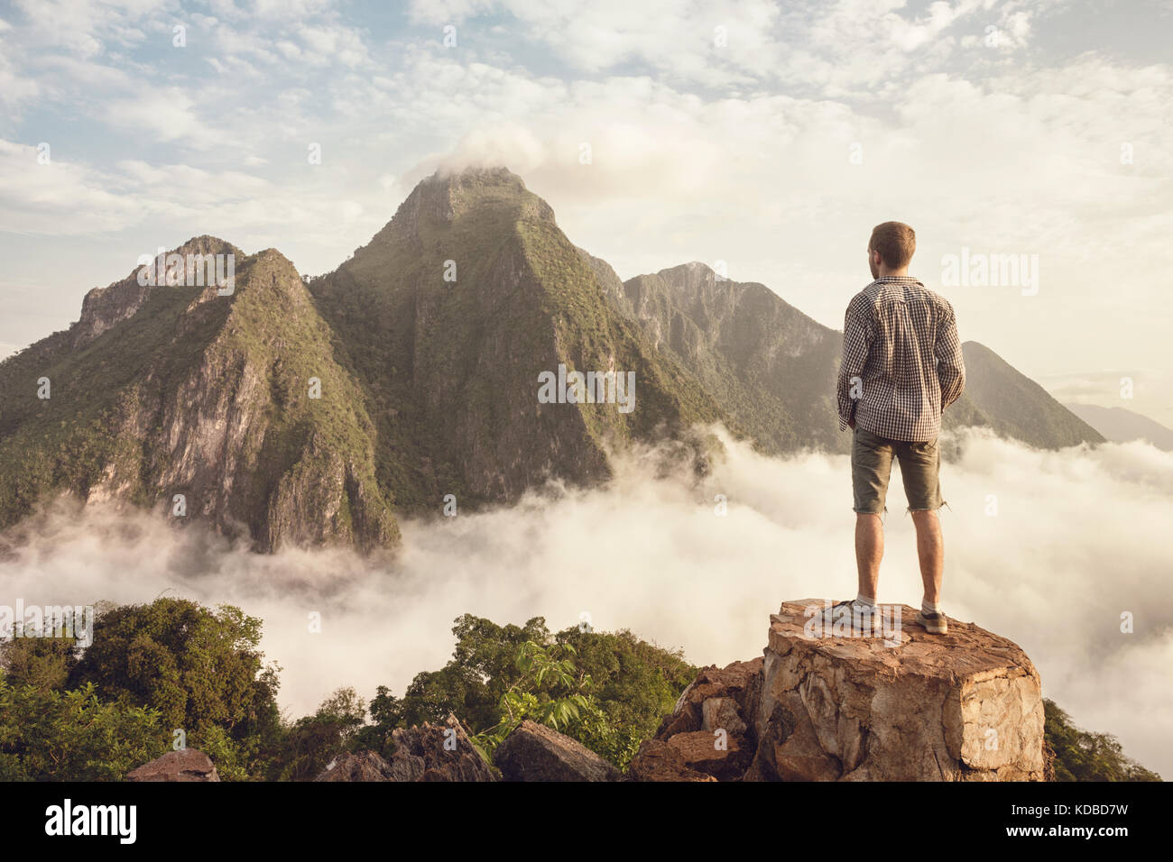 Man looks at a mountain panorama over the clouds Stock Photo - Alamy