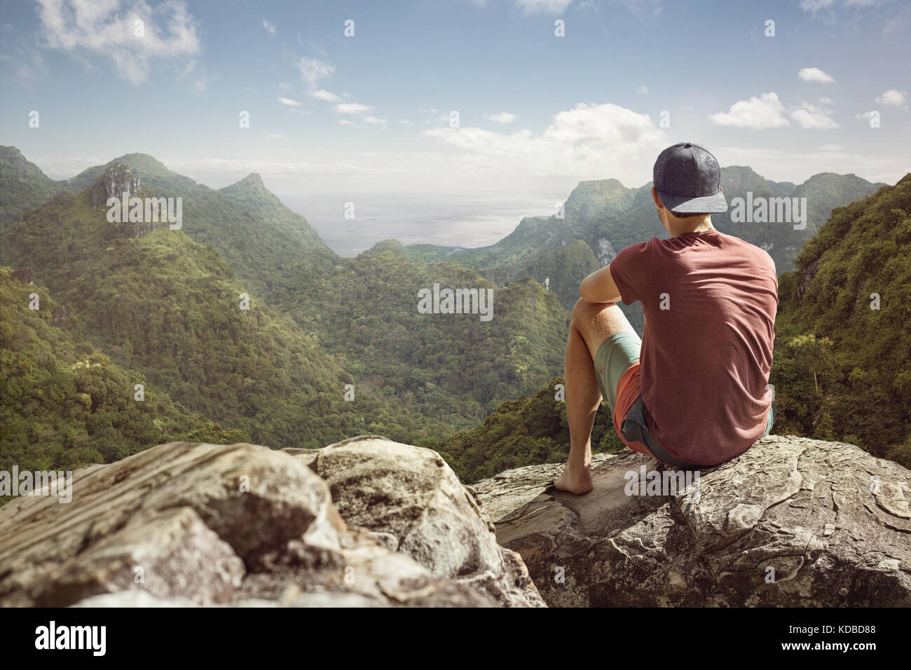 Young man has a panoramic view on a tropical landscape Stock Photo - Alamy