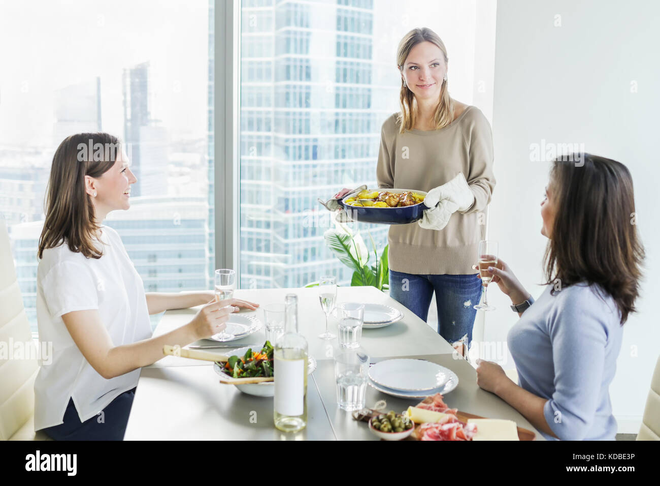 Young women having dinner together in modern kitchen Stock Photo - Alamy