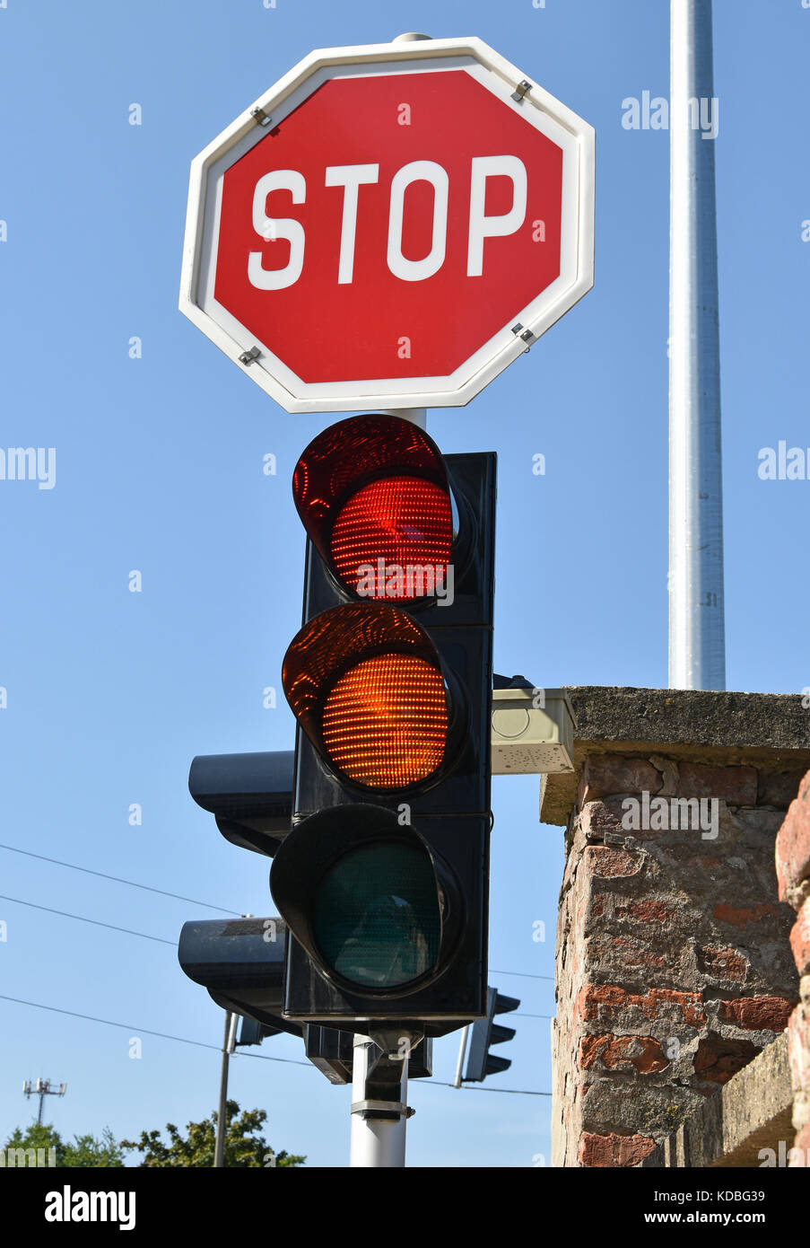 Stop sign and red light at the road crossing Stock Photo - Alamy