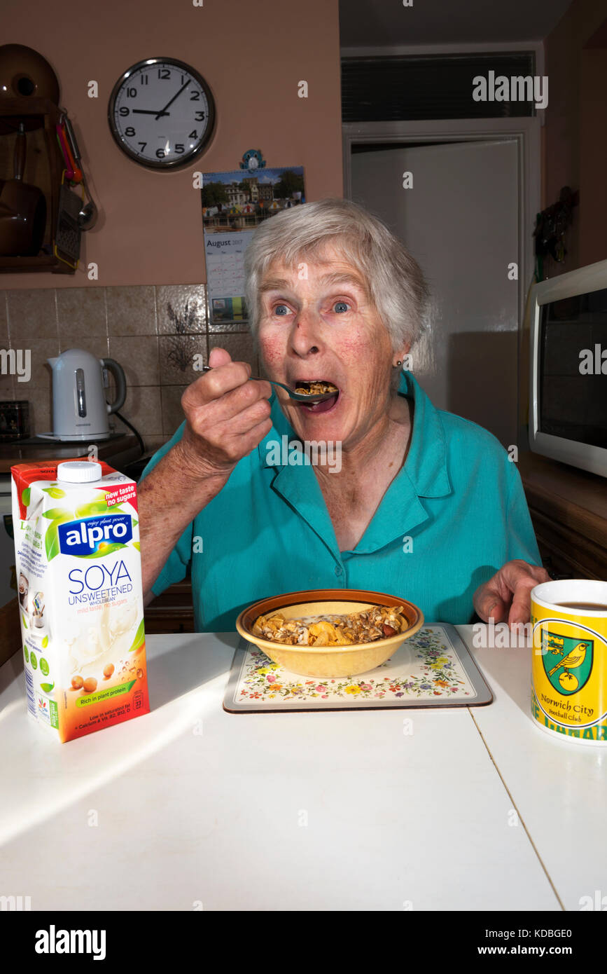 Elderly woman on a dairy free diet eating breakfast hi-res stock ...